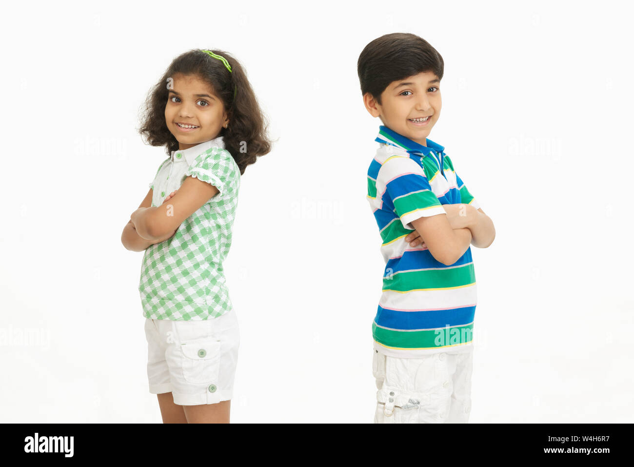 Two children standing back to back and smiling Stock Photo - Alamy