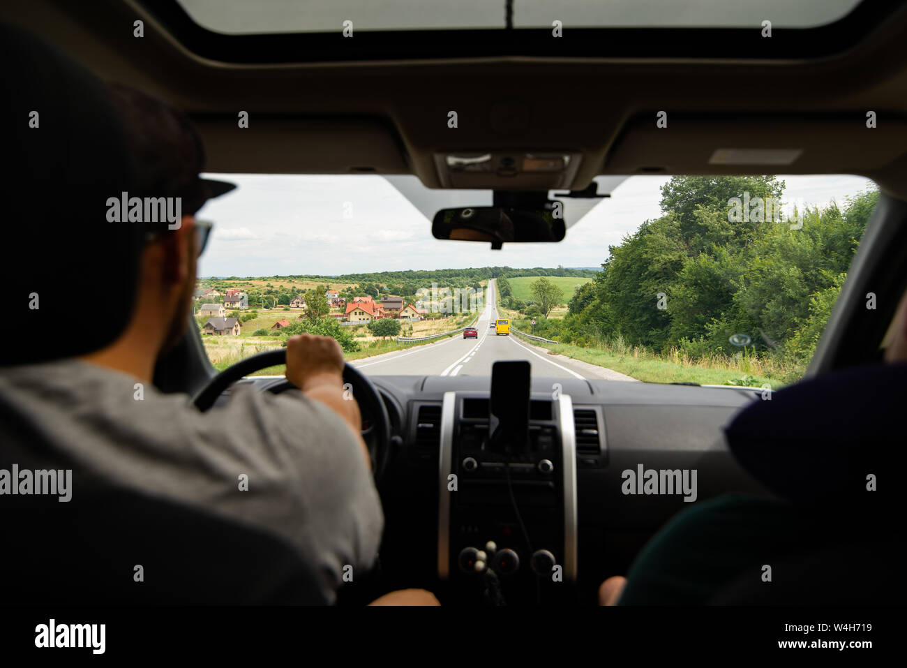 car travel concept view from inside young caucasian man driving car by ...