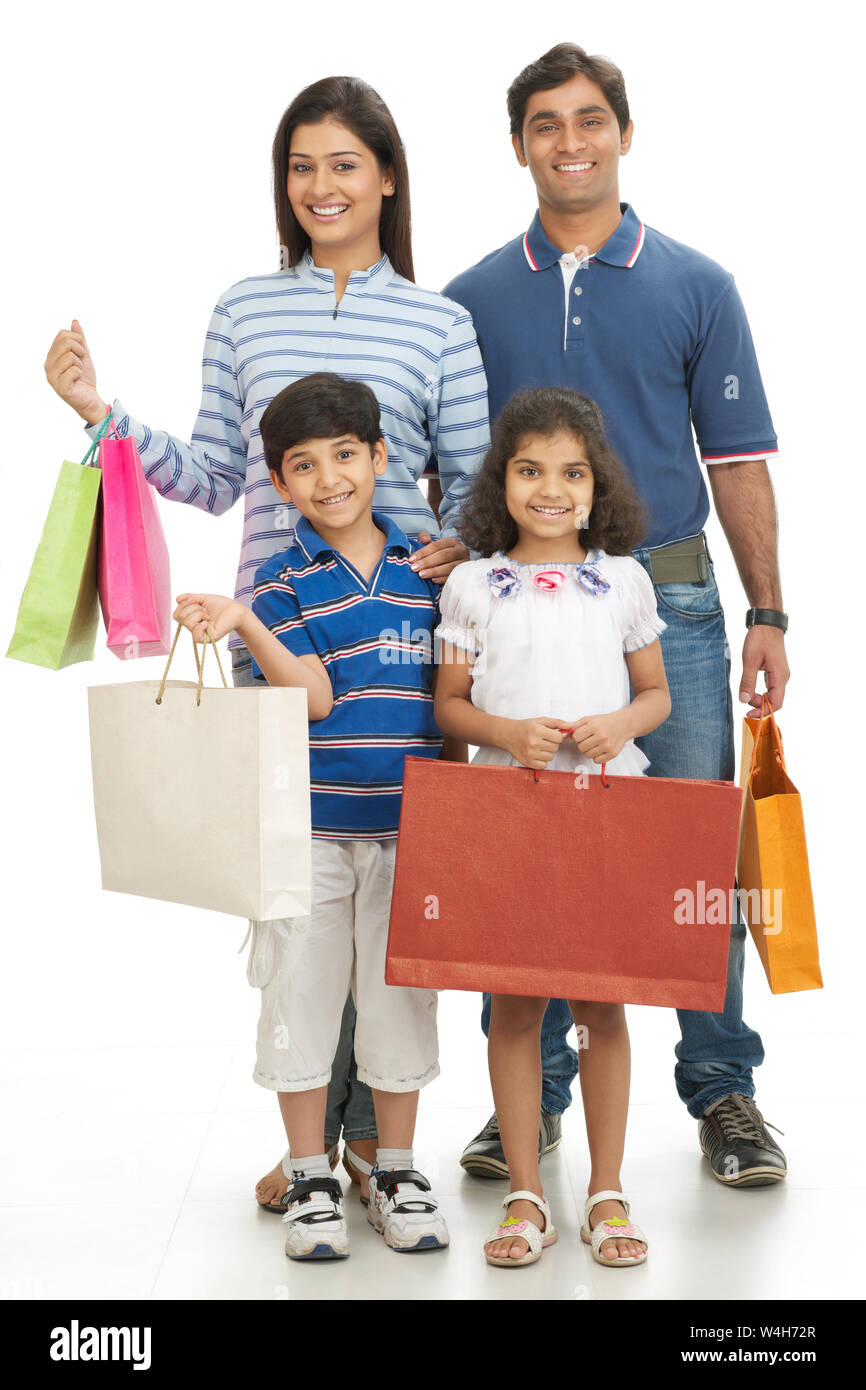 Family carrying shopping bags and smiling Stock Photo - Alamy
