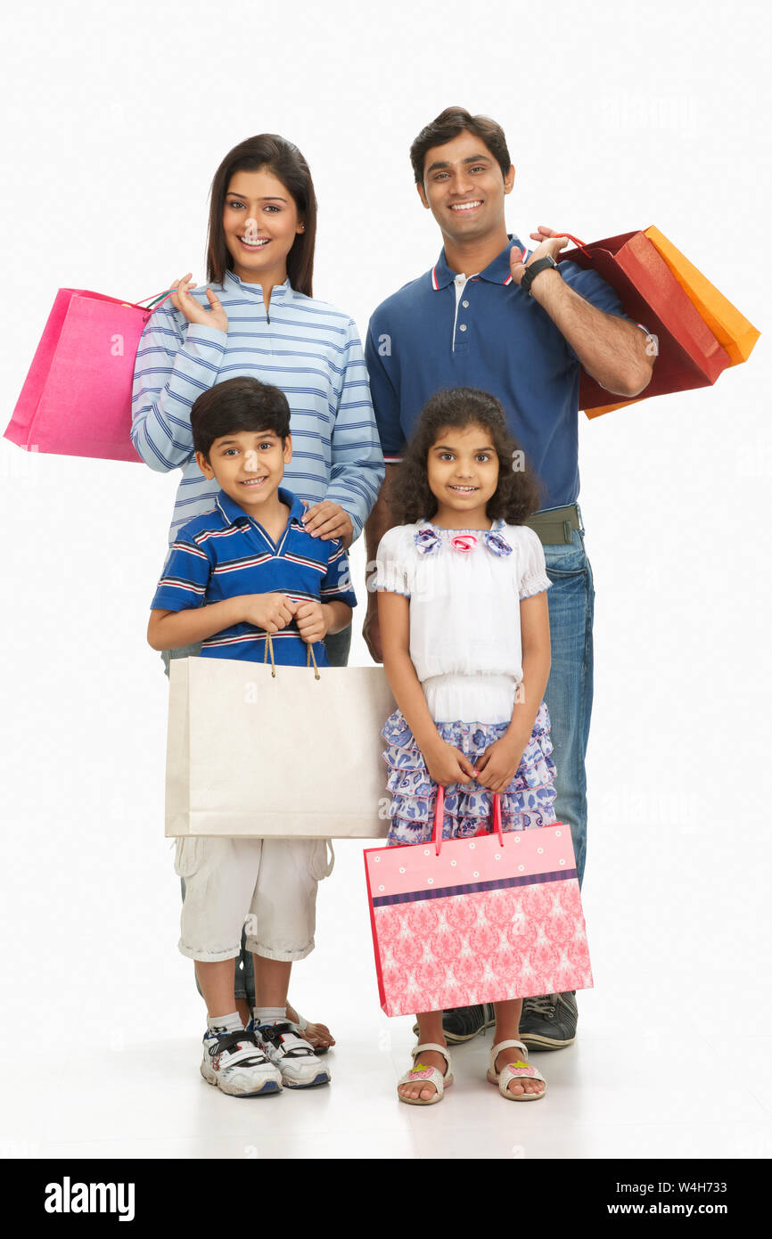 Family carrying shopping bags and smiling Stock Photo - Alamy