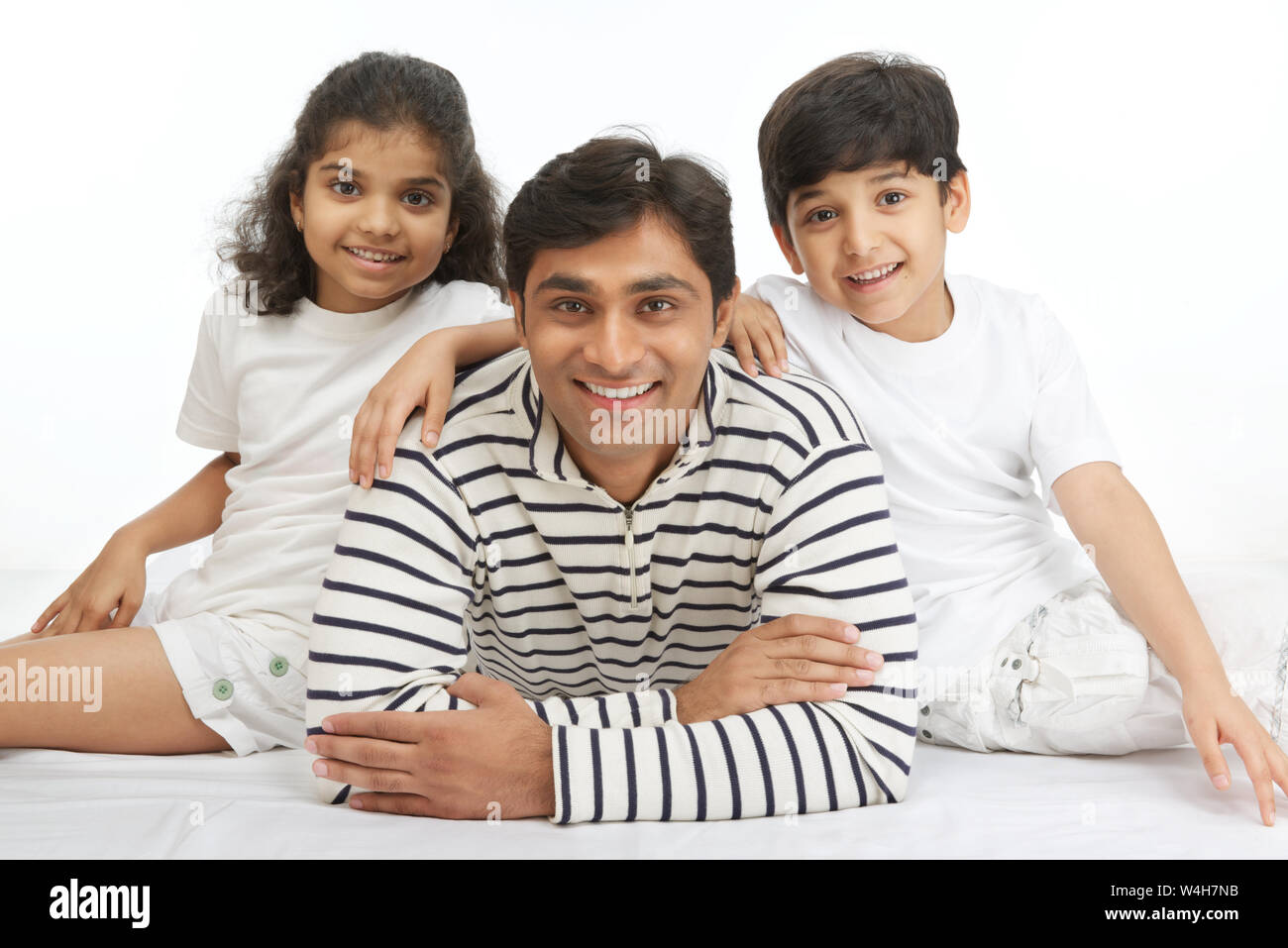 Father with two children lying on the bed Stock Photo - Alamy