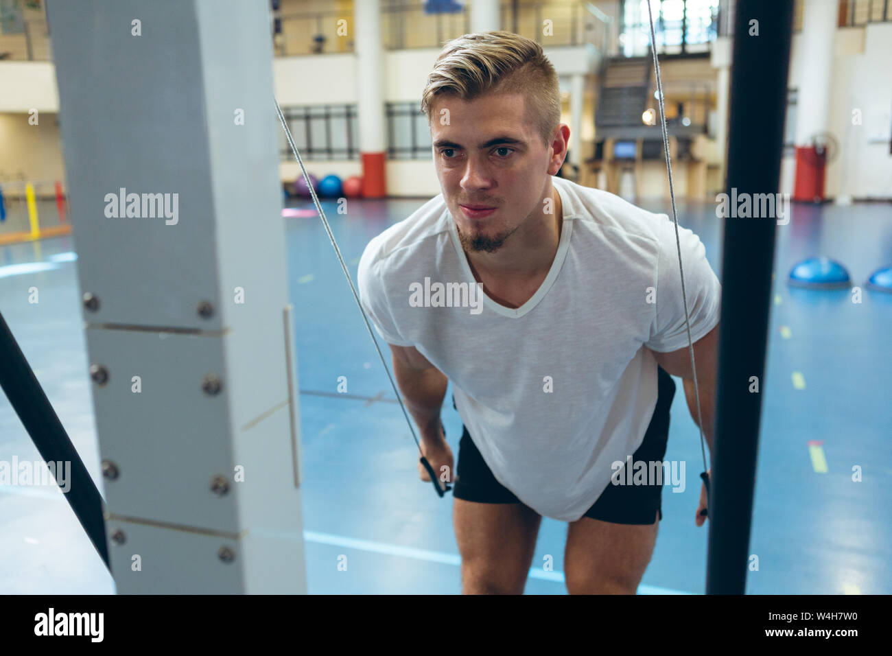Male athlete doing triceps exercise in fitness studio Stock Photo - Alamy