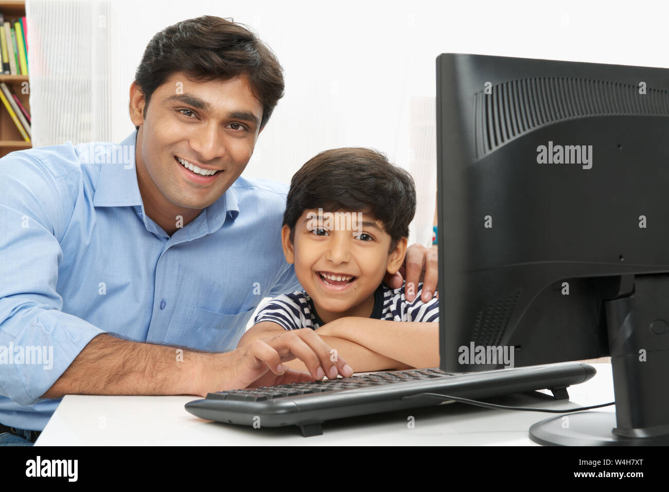 Man with his son using a computer at home Stock Photo - Alamy