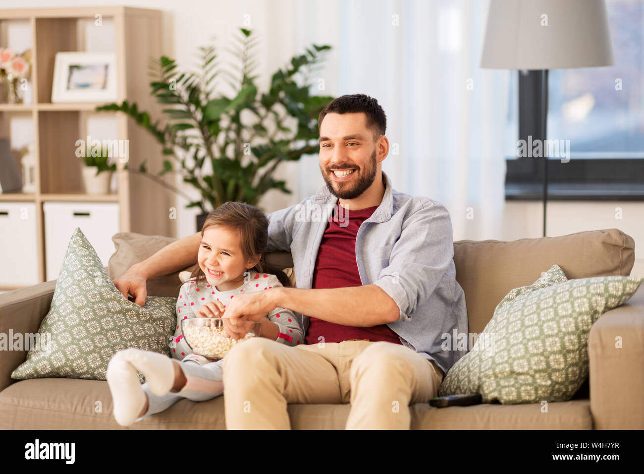 happy father and daughter watching tv at home Stock Photo - Alamy