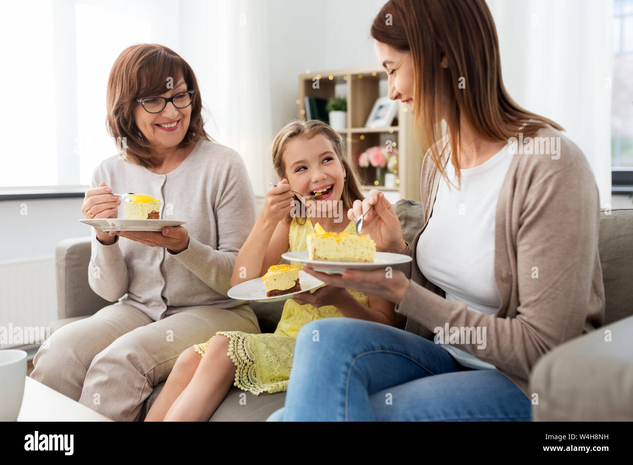 mother, daughter and grandmother eating cake Stock Photo - Alamy