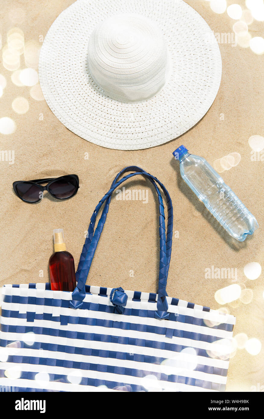 beach bag, sunscreen, sunglasses and hat on sand Stock Photo - Alamy