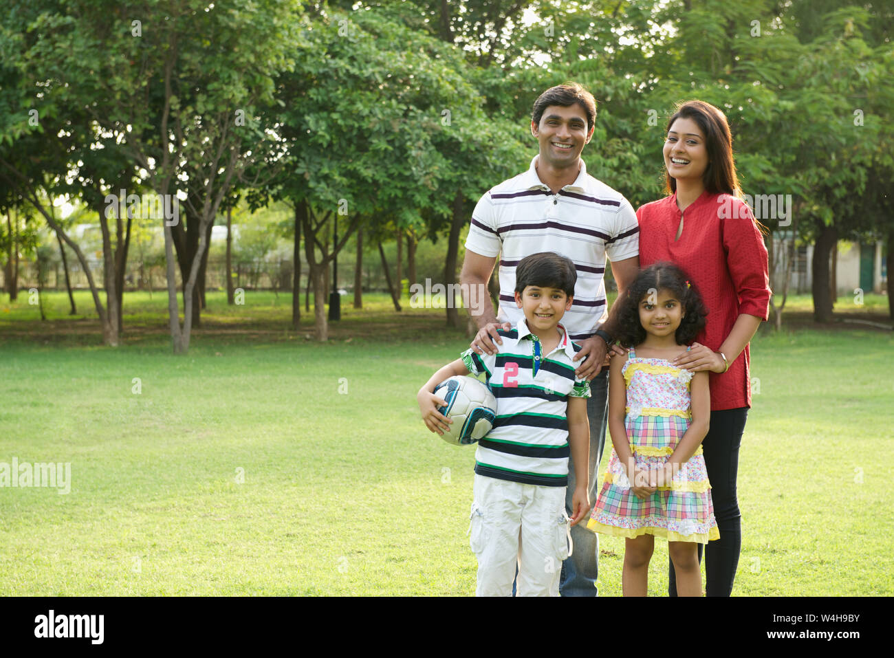 Family standing together in a lawn Stock Photo - Alamy