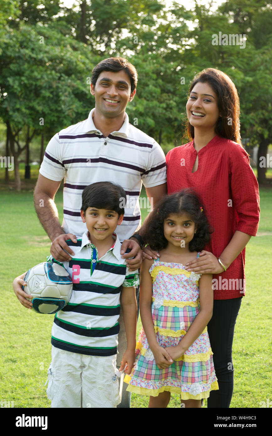 Family standing together in a lawn Stock Photo - Alamy