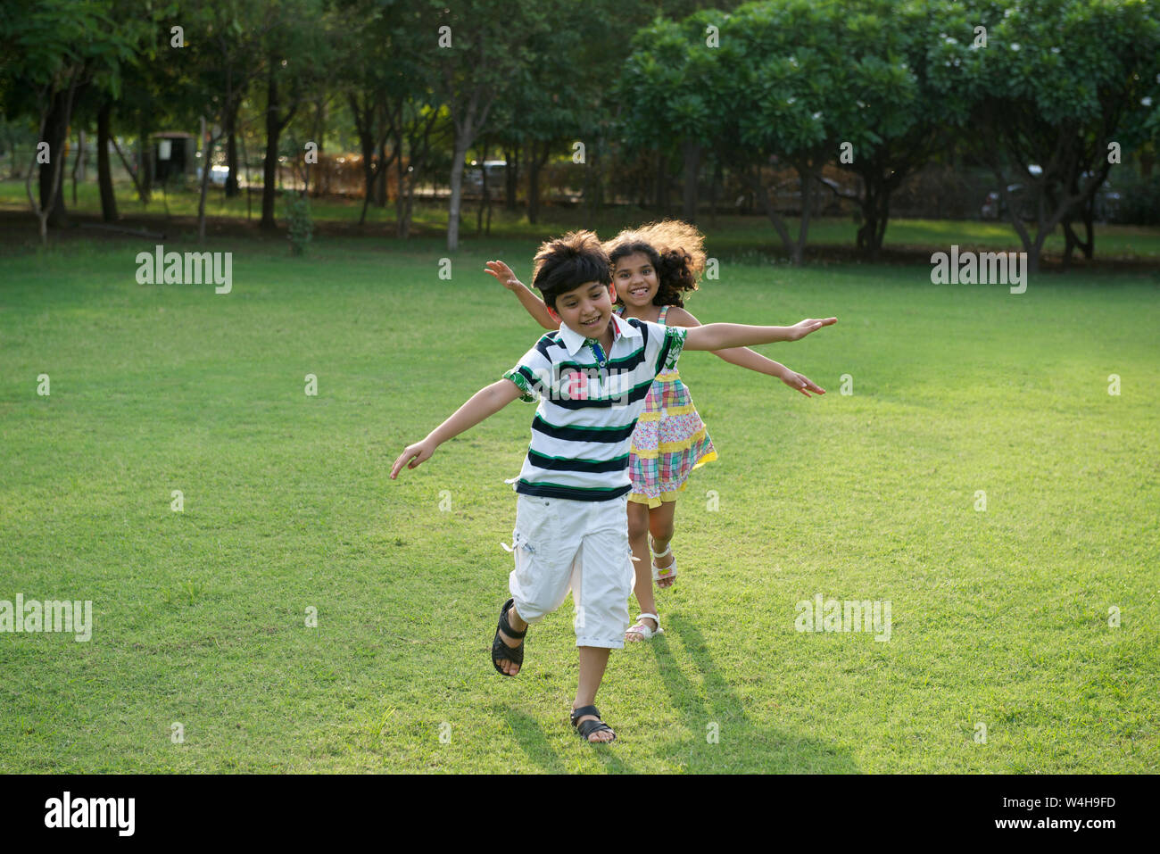 Two children playing in a lawn Stock Photo - Alamy