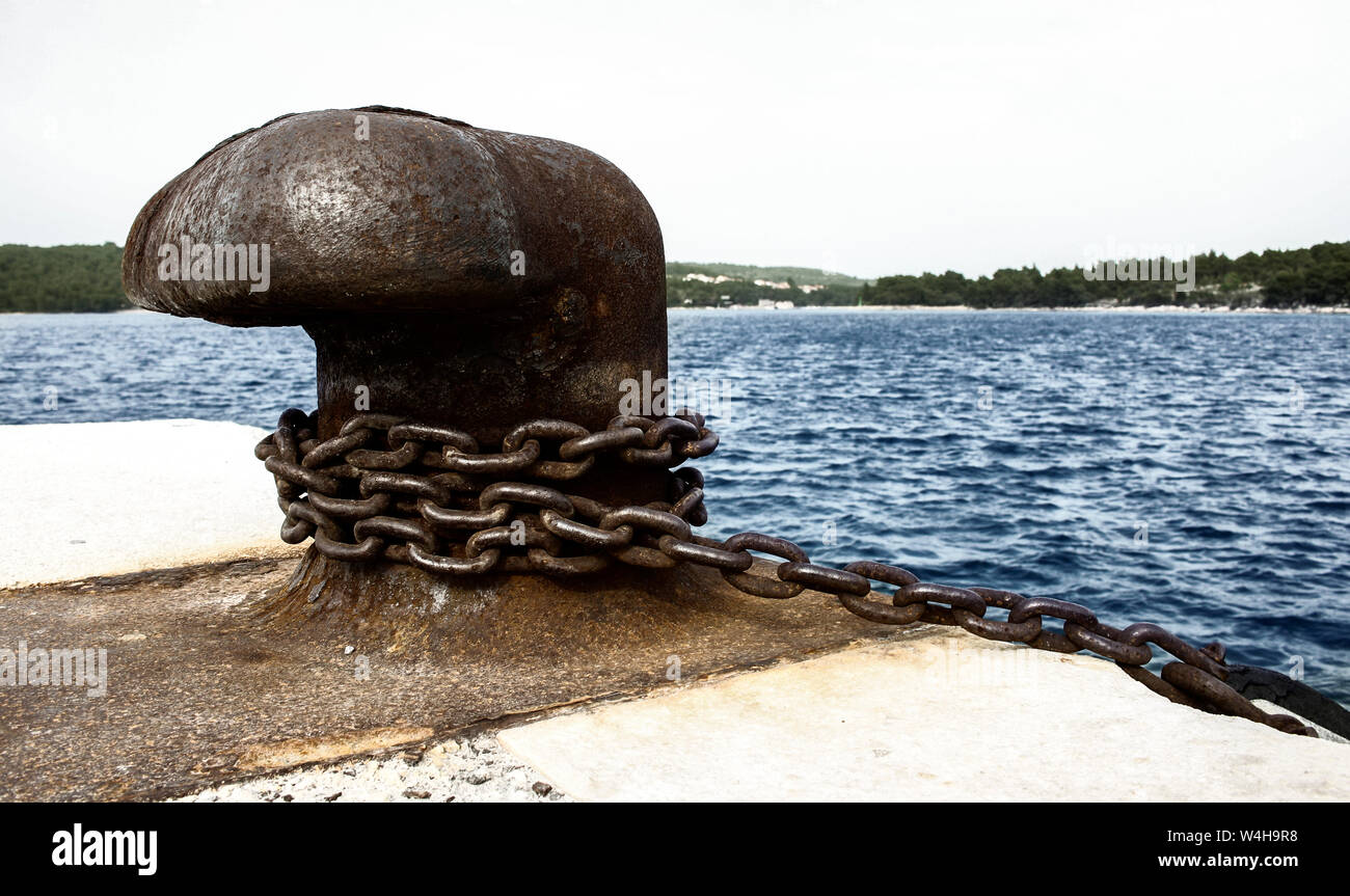 Old and rusty mooring post on concrete dock of harbor Stock Photo - Alamy