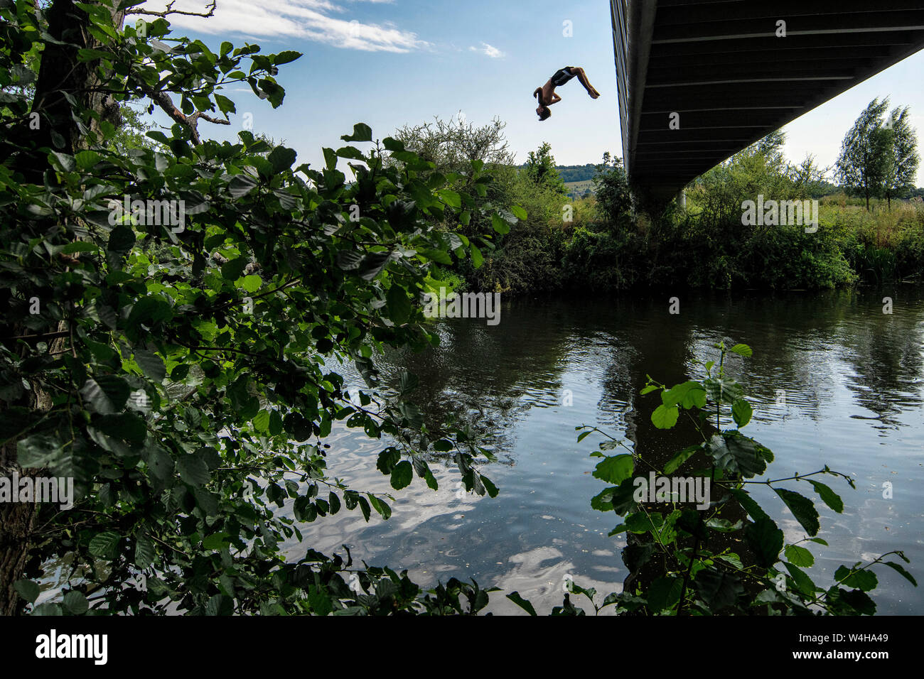 A teenage boy backflips from a footbridge into the River Avon at ...