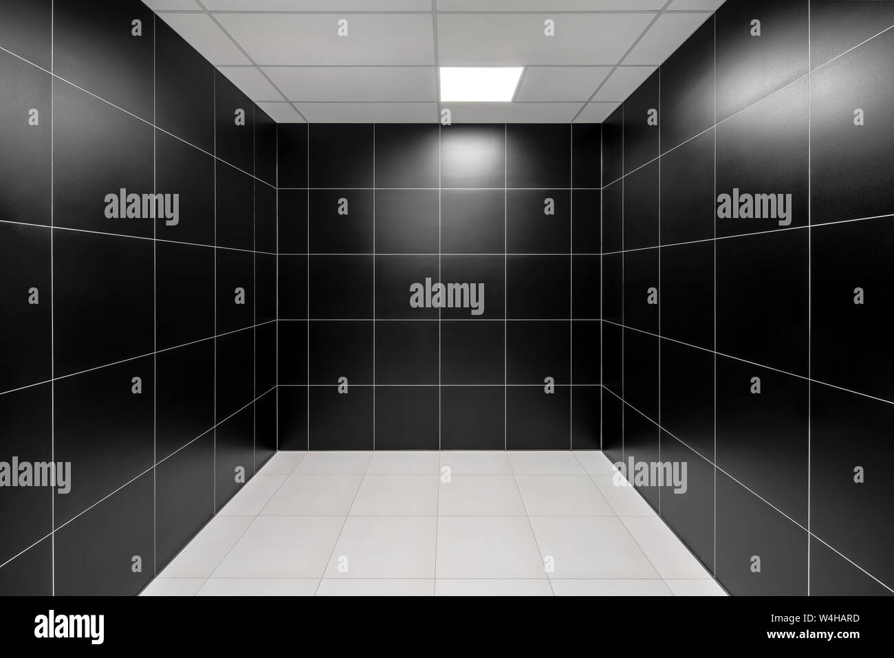 Room in with tiled dark walls and light floor Stock Photo - Alamy