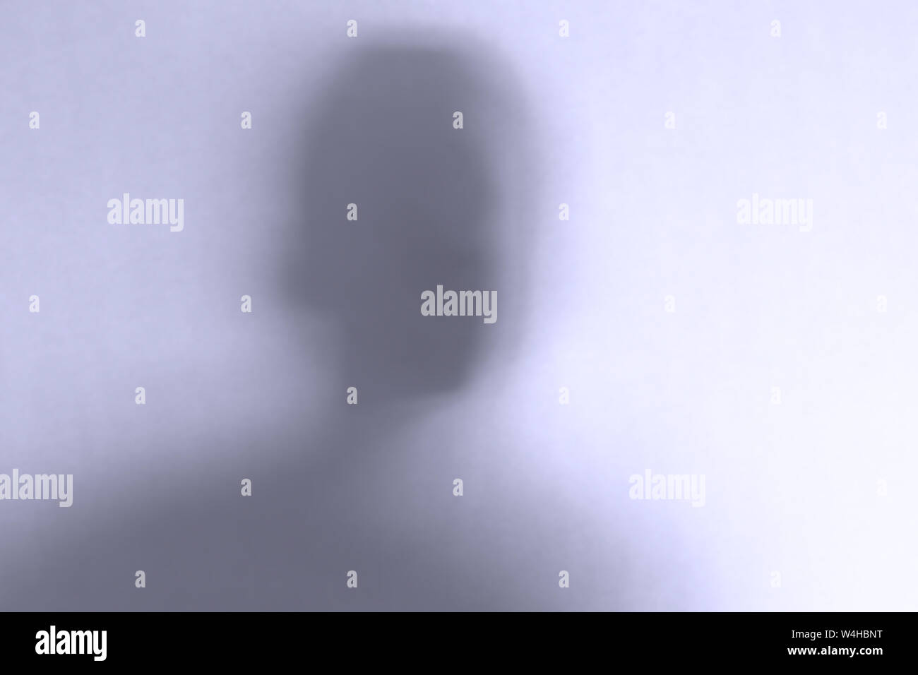 Blurred scary ghost face behind a white glass background. Horizontal ...