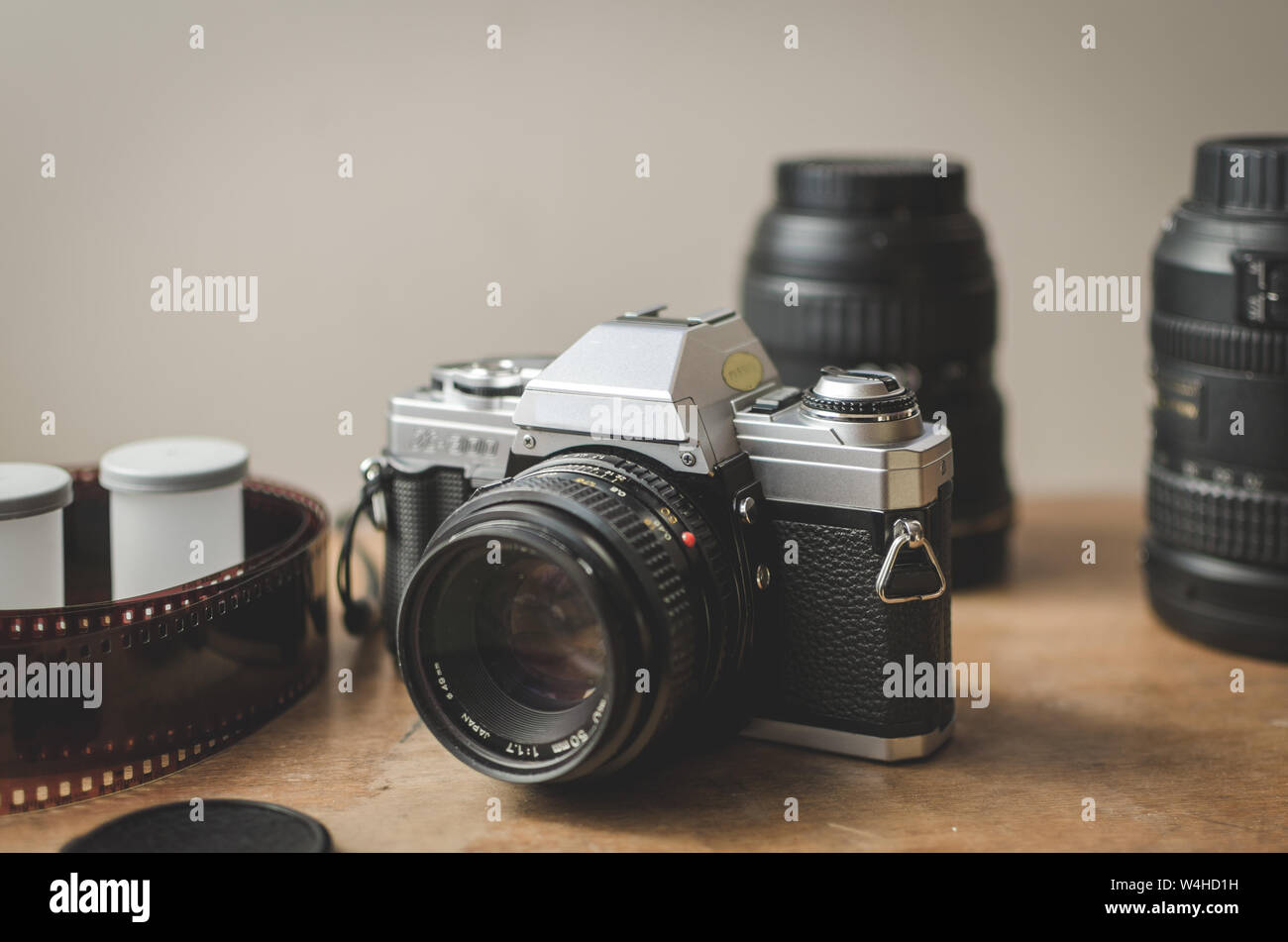 Horizontal view of a vintage 35mm analog camera surrounded with lenses ...