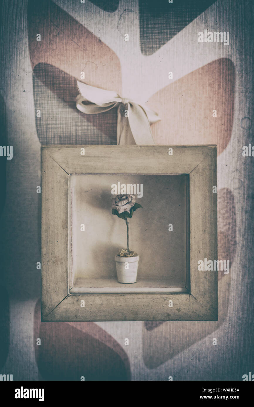 Small vase with rose inside a small picture frame with wooden frame ...