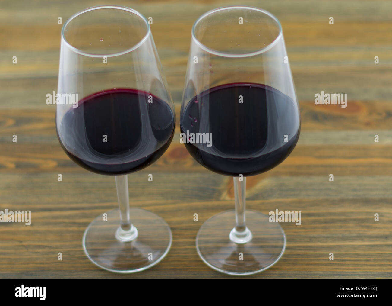Two glasses of red wine on wood background Stock Photo - Alamy