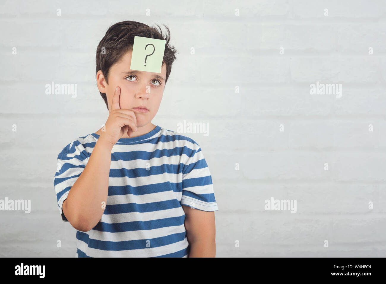 Child thinking with question mark in memo post on his forehead over ...