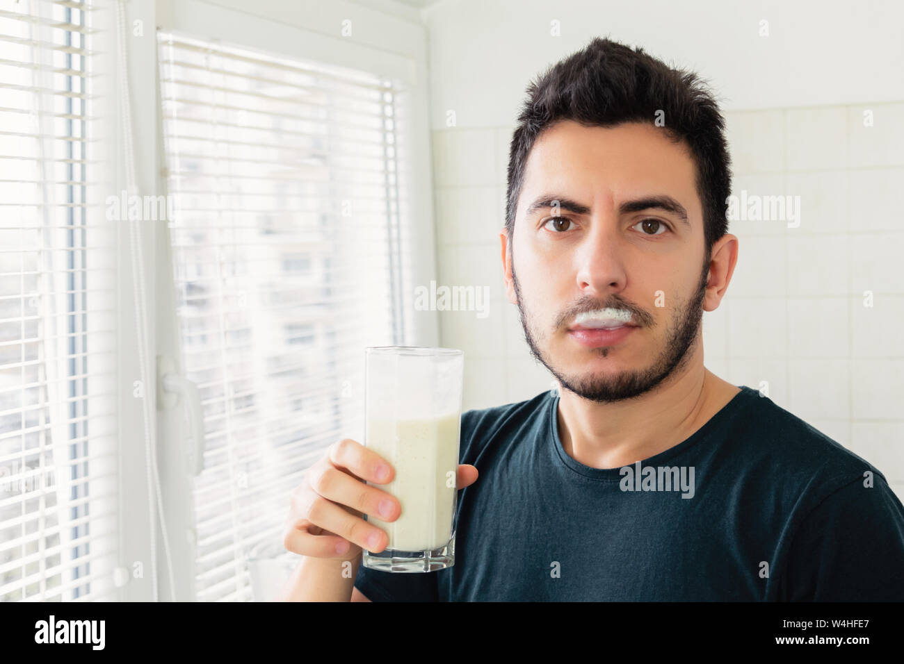 A young man prepared himself for breakfast a smoothie of vegetable milk ...
