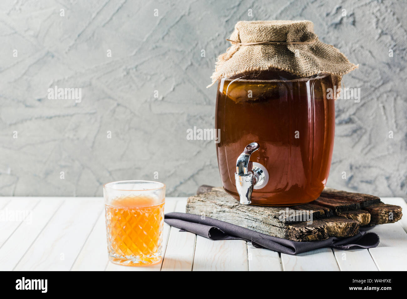 Kombucha tea drink with beneficial bacteria on wooden white background ...