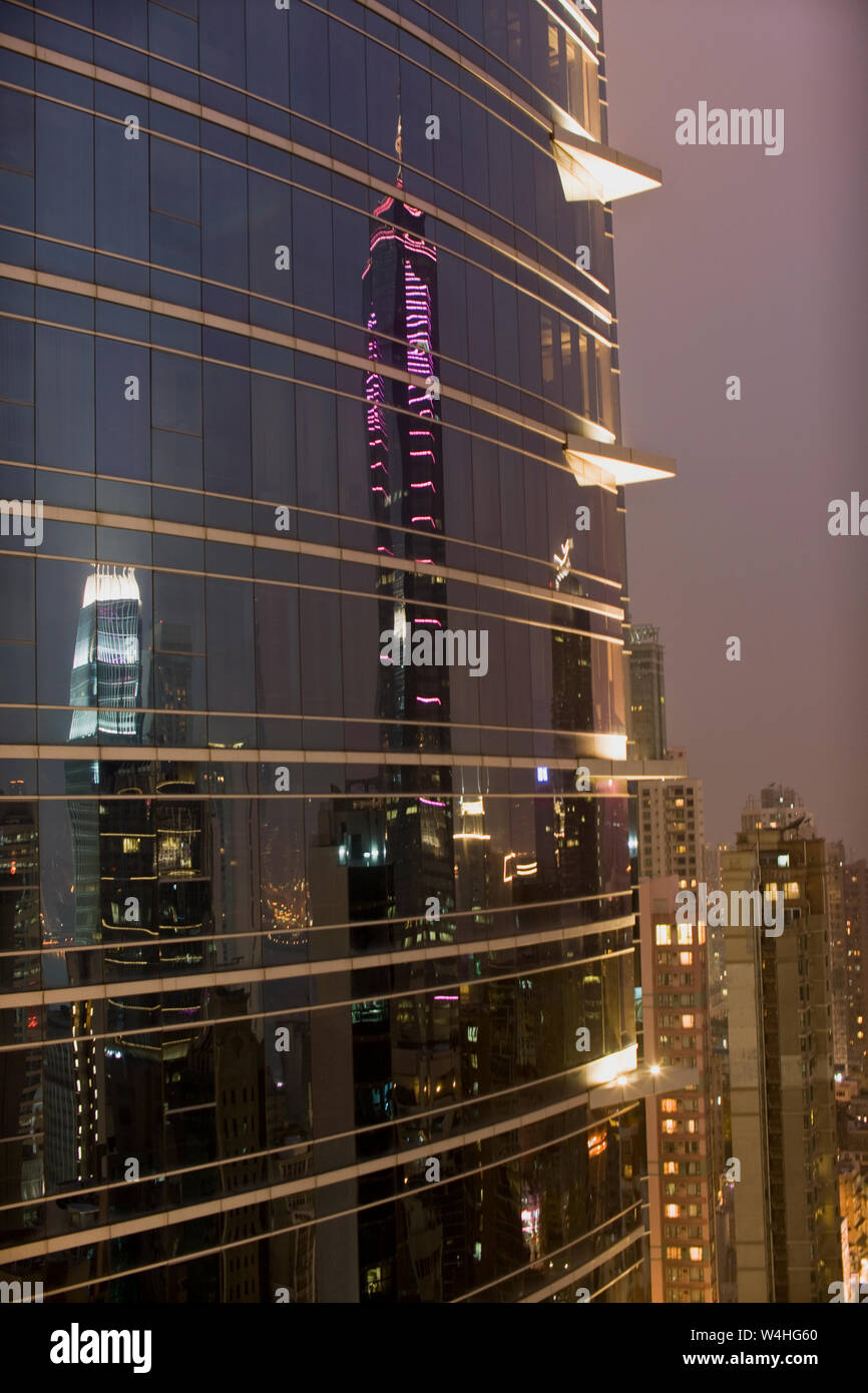 Lights of tall skyscrapers reflecting in the window of another building ...