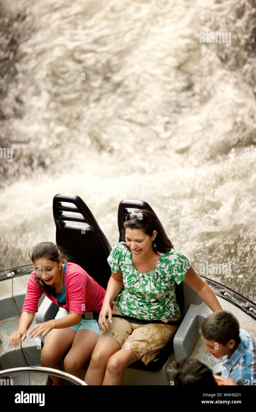 Smiling family on a water ride at an amusement park Stock Photo - Alamy