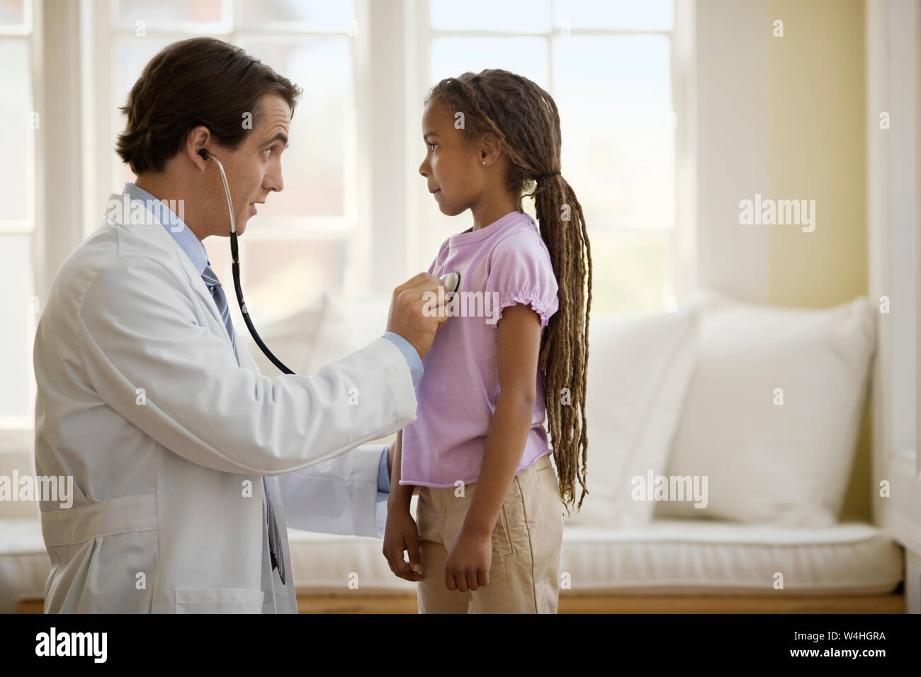 Doctor listening to a young girl's heartbeat with a stethoscope Stock ...