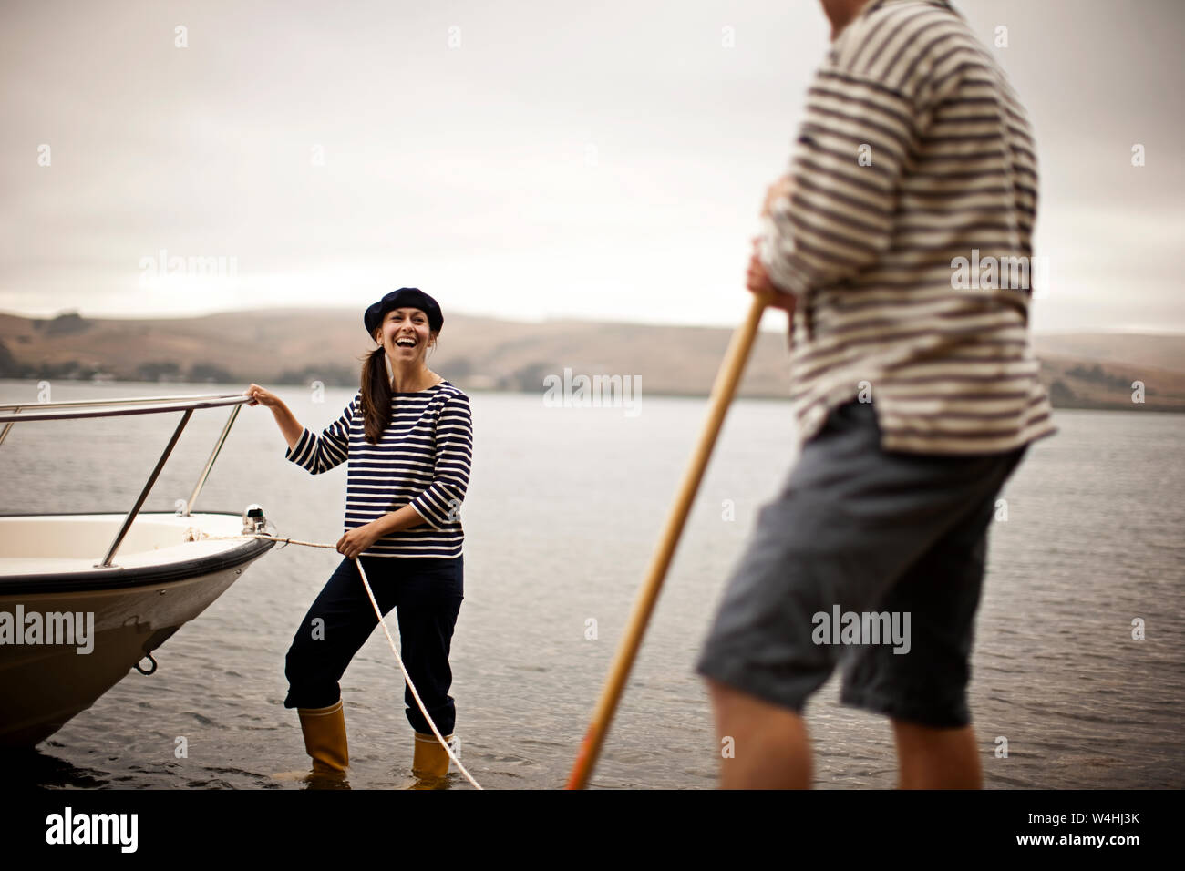 Woman laughing at her partner as she anchors their boat Stock Photo - Alamy