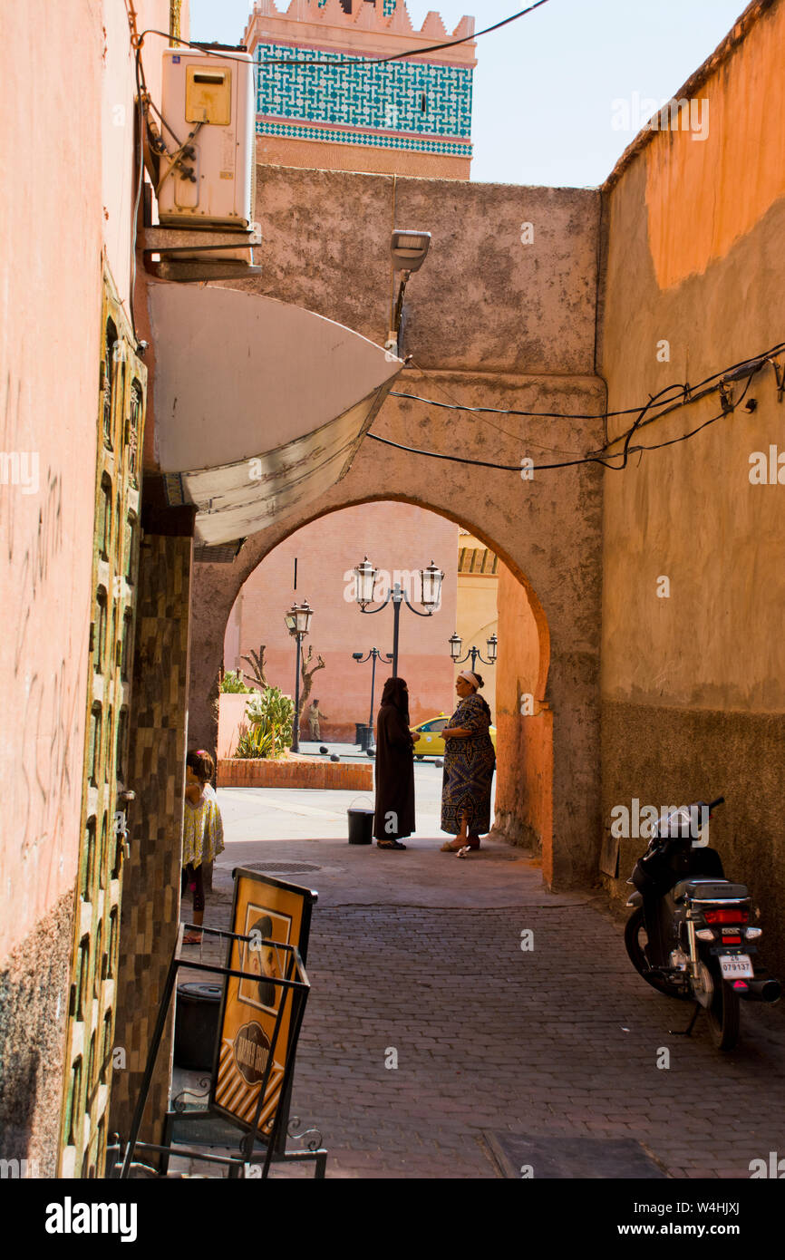 Moroccan street scene, local woman meet in alleyeway in Marrakech ...