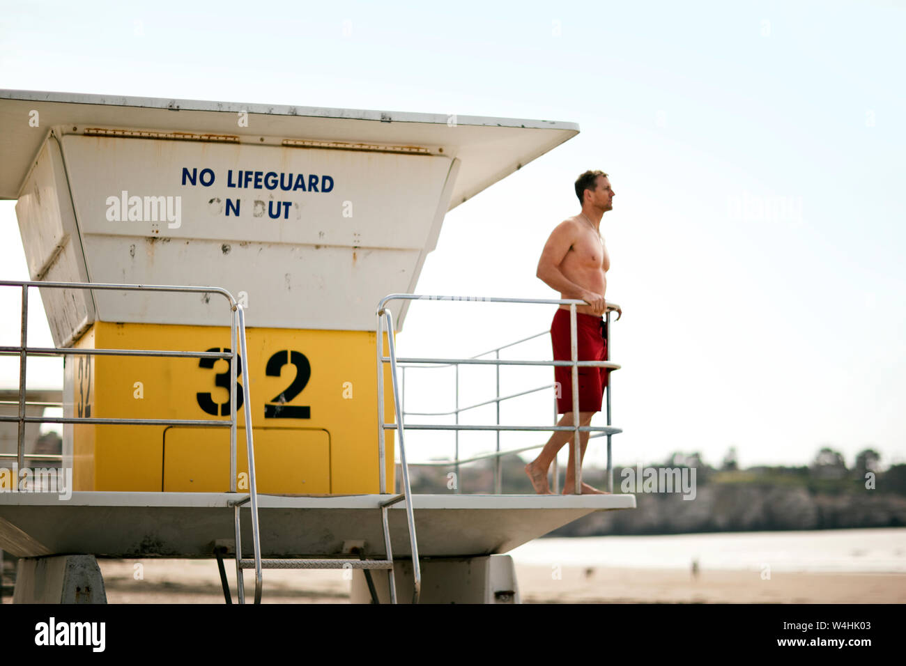 Lifeguard in lifeguard tower surveying the beach Stock Photo - Alamy