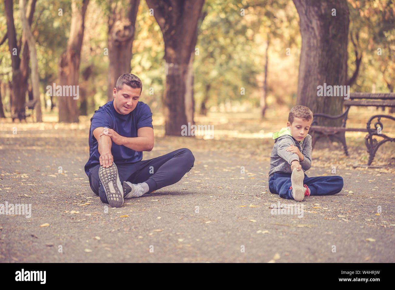 Little boy and his father doing stretching exercise together in the ...