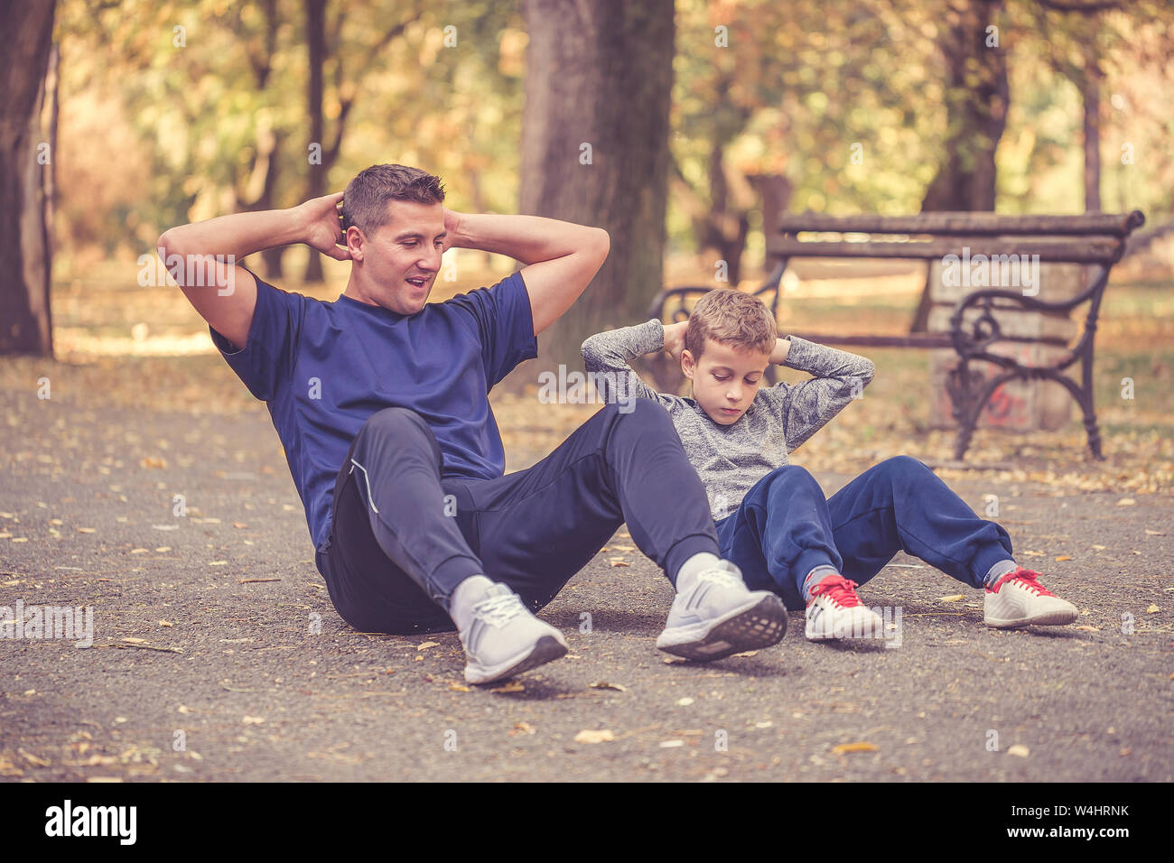 Little boy and his father doing stretching exercise together in the ...