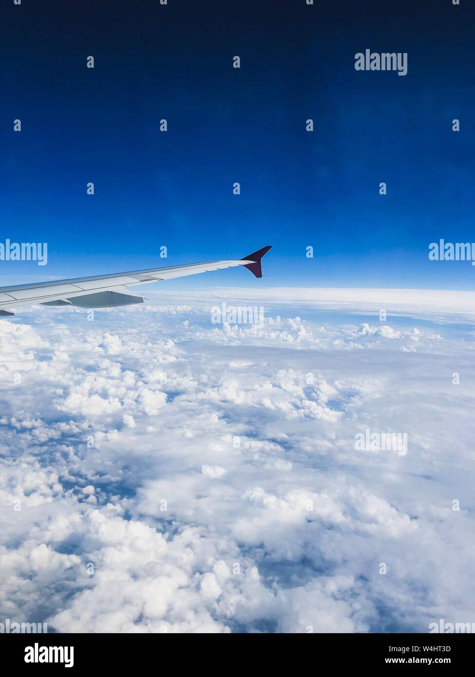 View out of airplane window showing the end of an airplane wing over ...