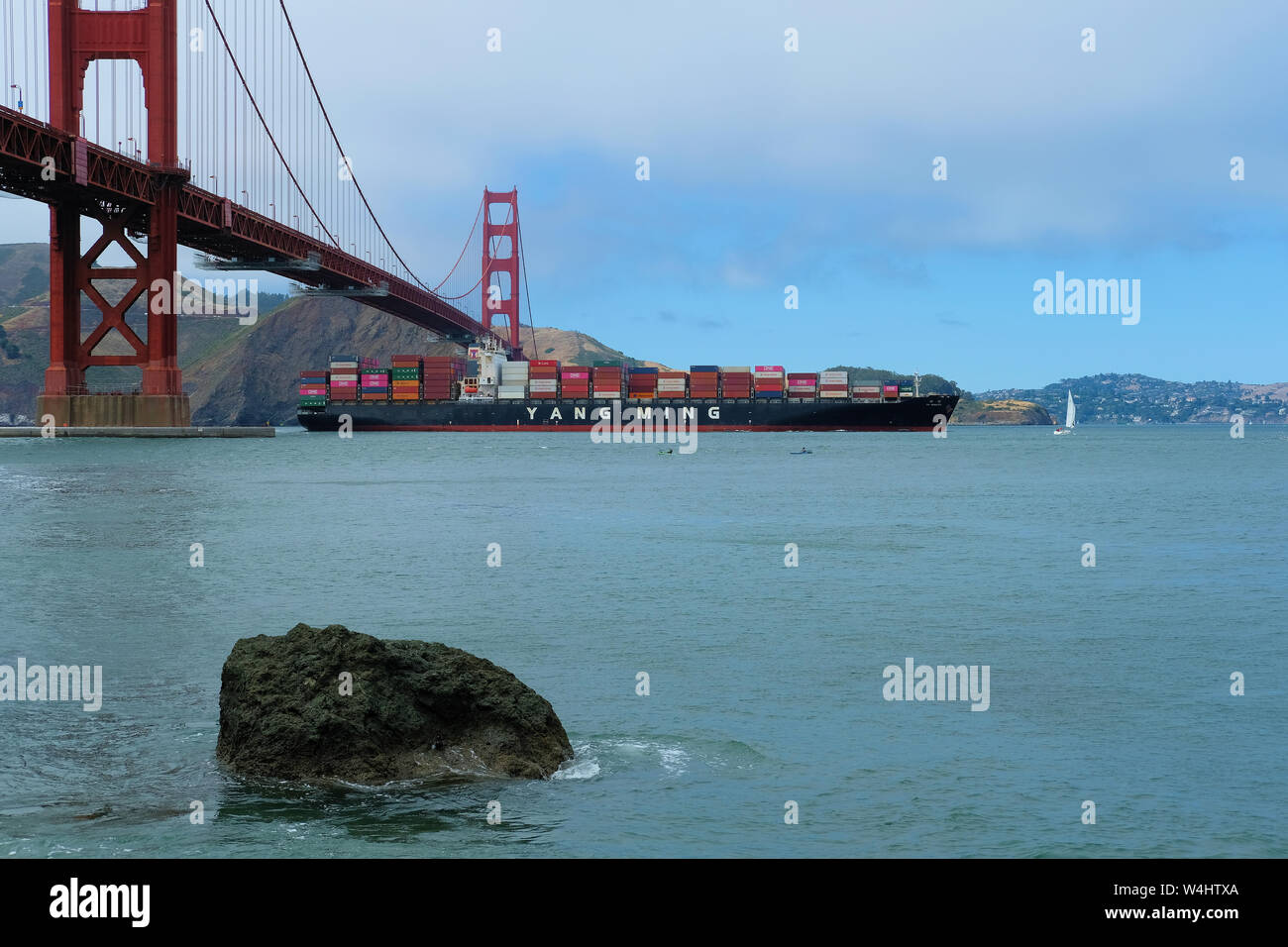 A Yang Ming marine transport ship crossing under the Golden Gate Bridge ...