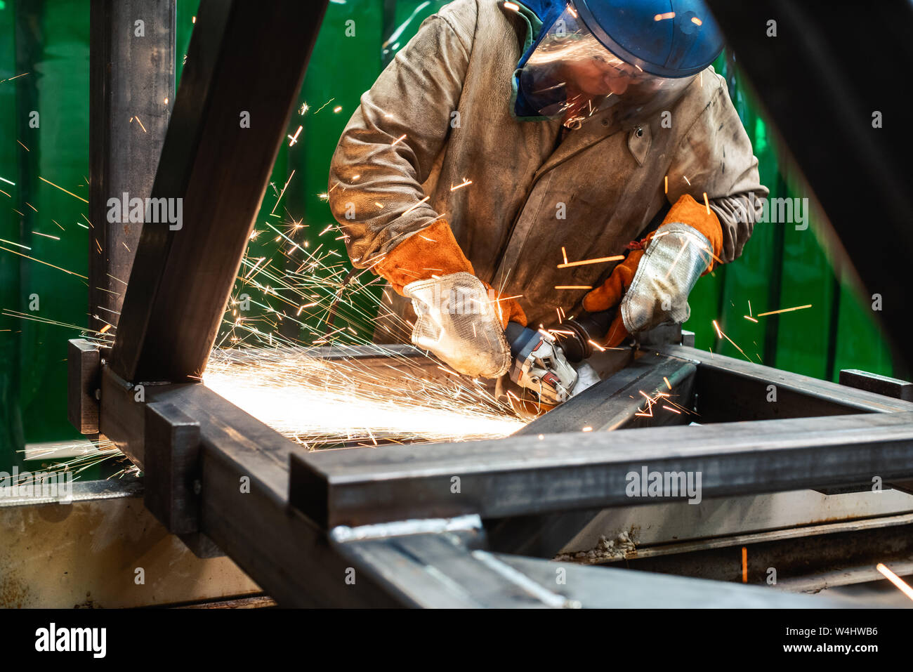 Metalworker working with angle grinder Stock Photo - Alamy