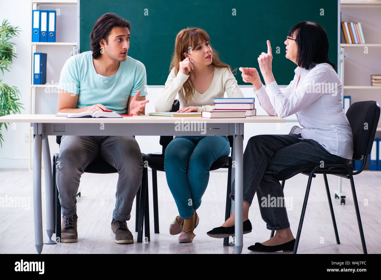 Old teacher and students in the classroom Stock Photo - Alamy
