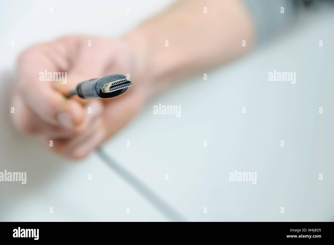 The hand of man is holding the cable plug hdmi Stock Photo - Alamy