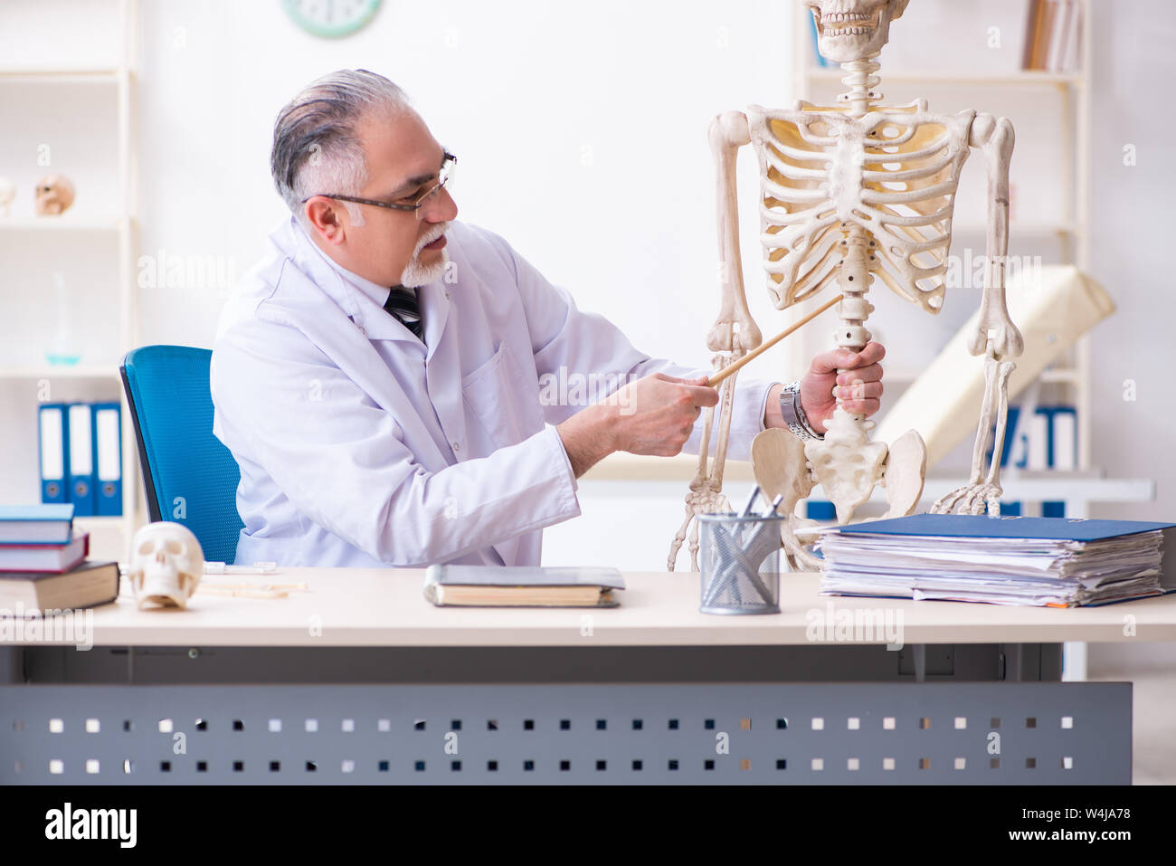The aged male doctor with skeleton Stock Photo - Alamy