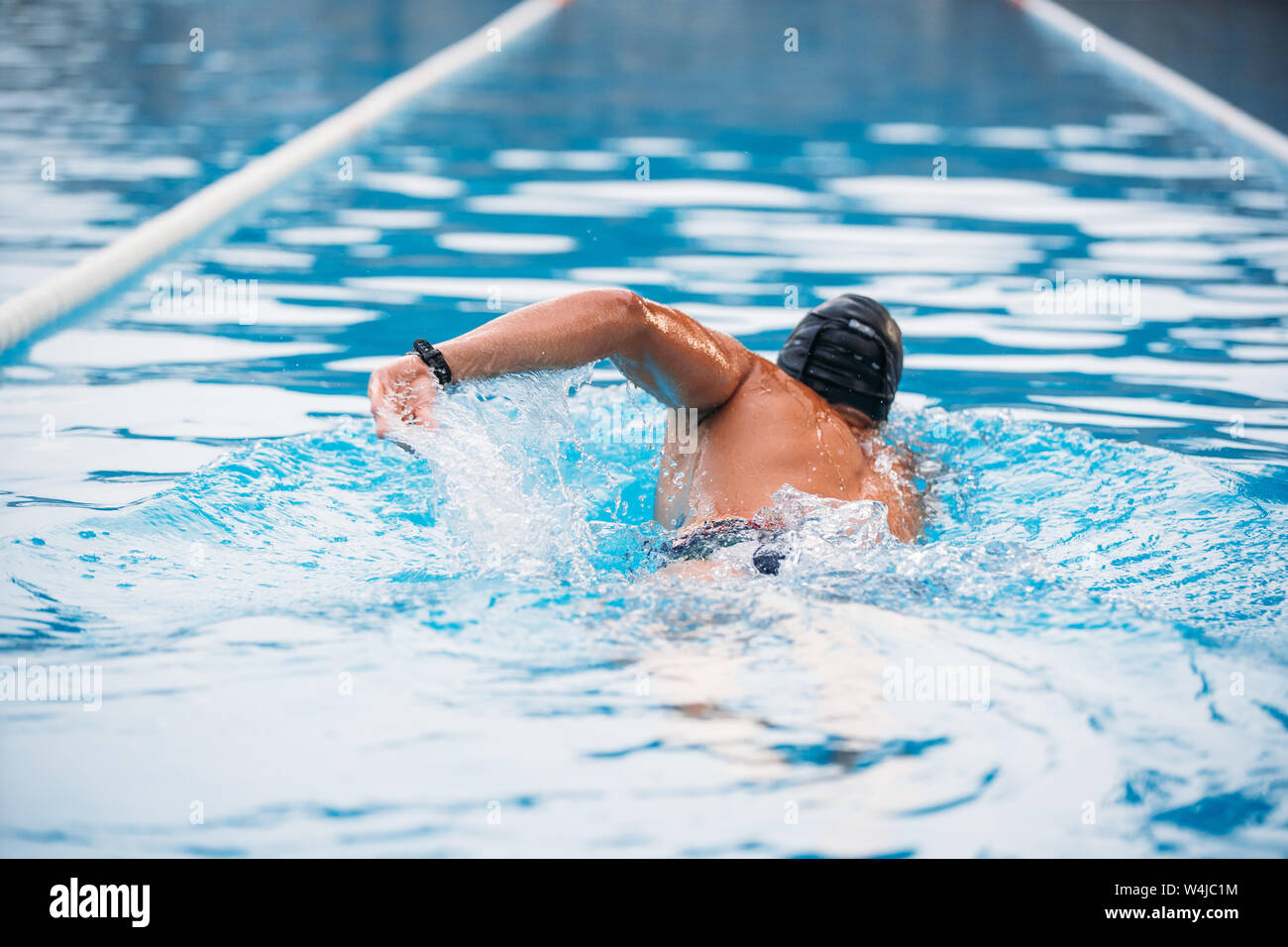 Athletic Young man swimming the back crawl in a pool. Swimming ...