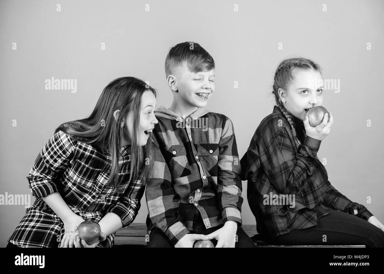 Boy and girls friends eat apple snack while relaxing. Healthy dieting ...