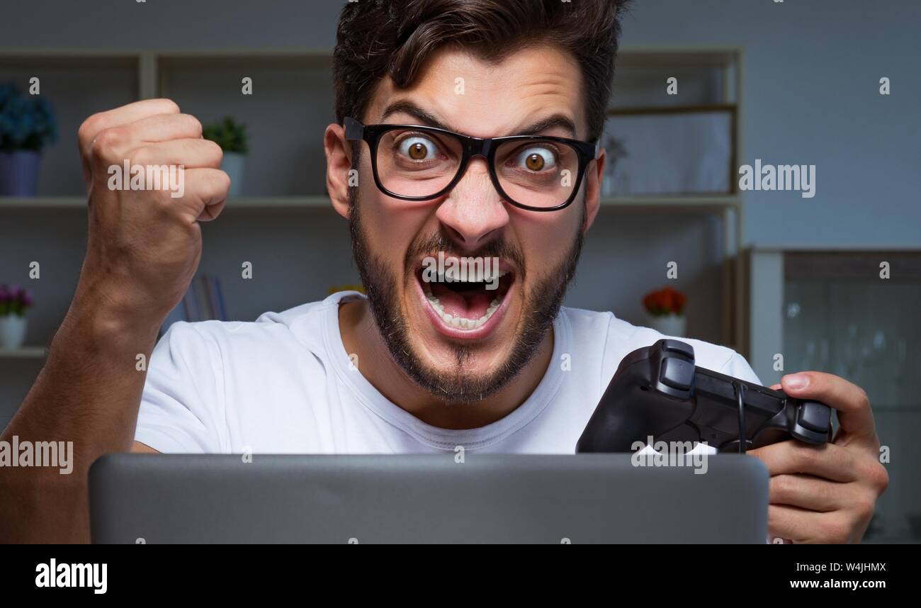 Young man playing games long hours late in the office Stock Photo - Alamy