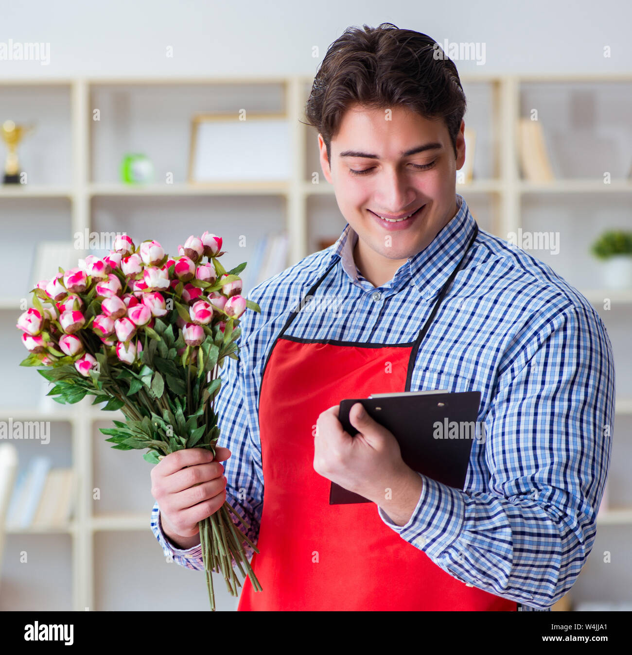 Flower shop assistant offering a bunch of flowers Stock Photo - Alamy