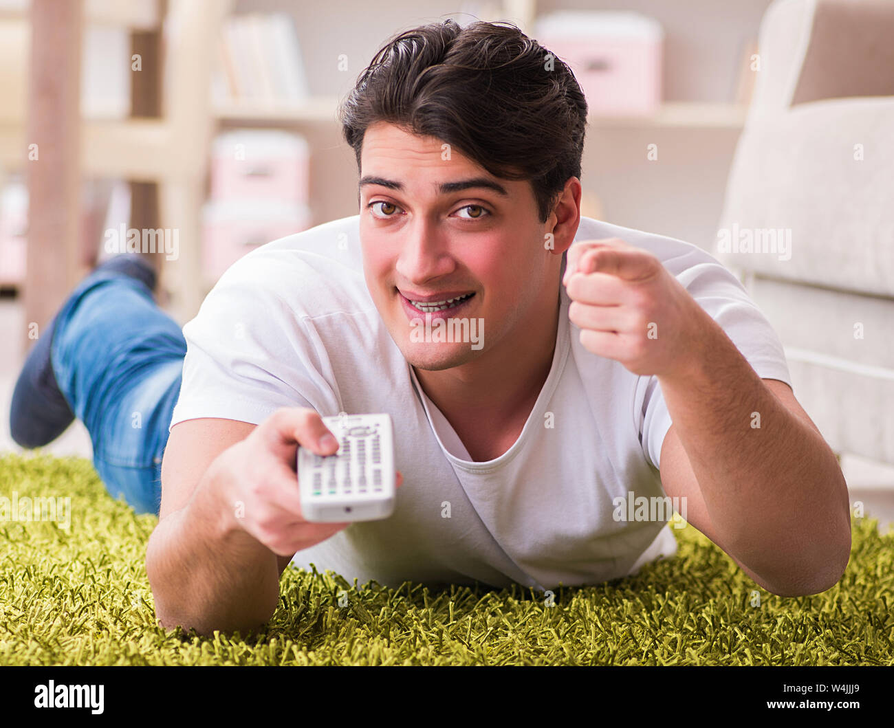 Man watching tv at home on floor Stock Photo - Alamy