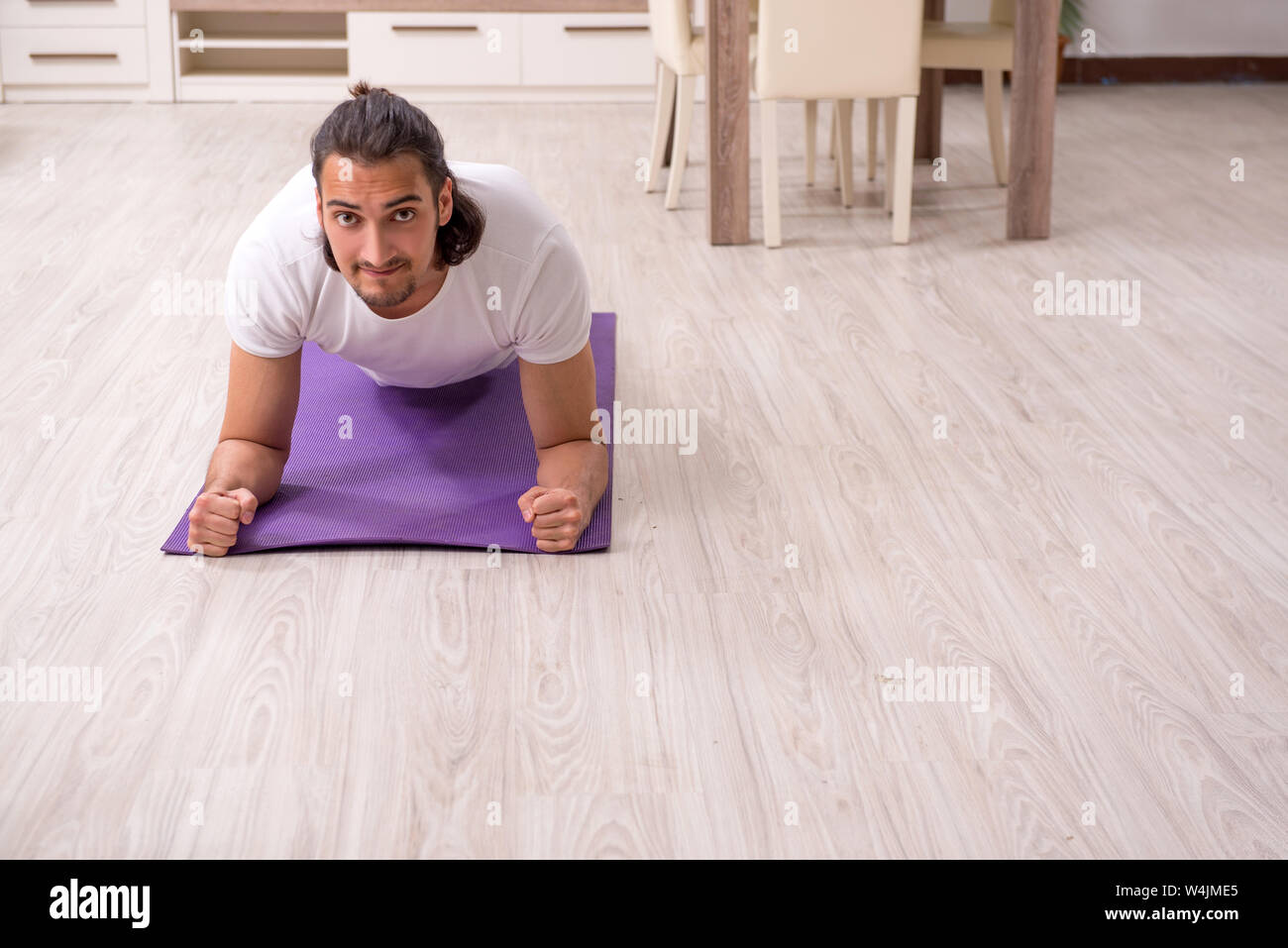 Young man doing physical exercises at home Stock Photo - Alamy