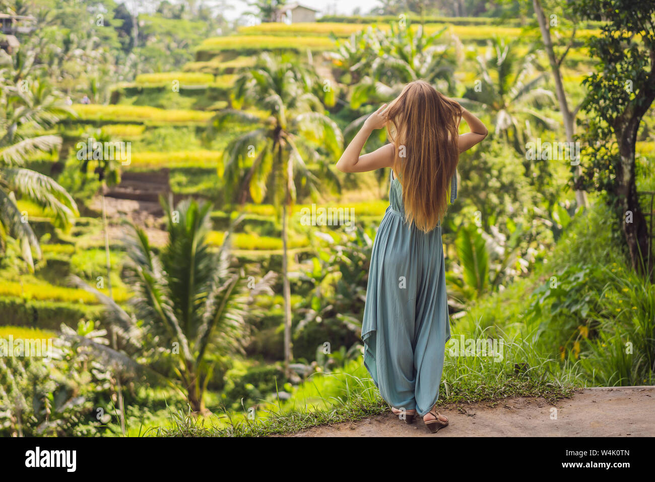 Beautiful young woman walk at typical Asian hillside with rice farming ...