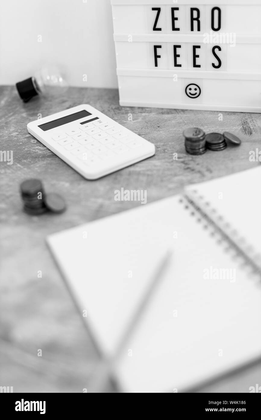 zero fees message on lightbox surrounded by coins calculator on office ...