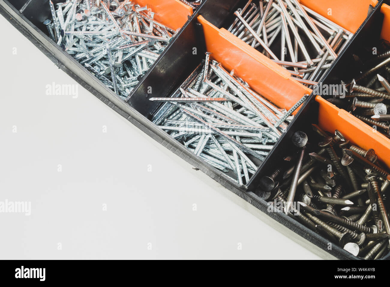 Various metal nails in toolbox background. nails in the cells of the ...