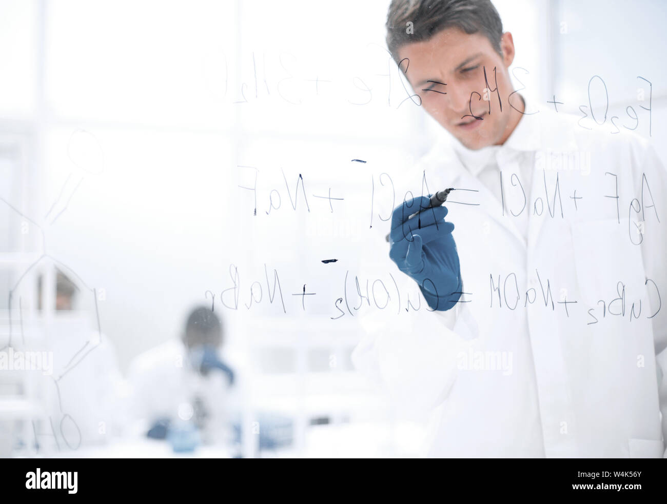 serious scientist writes a formula on a glass Board Stock Photo - Alamy