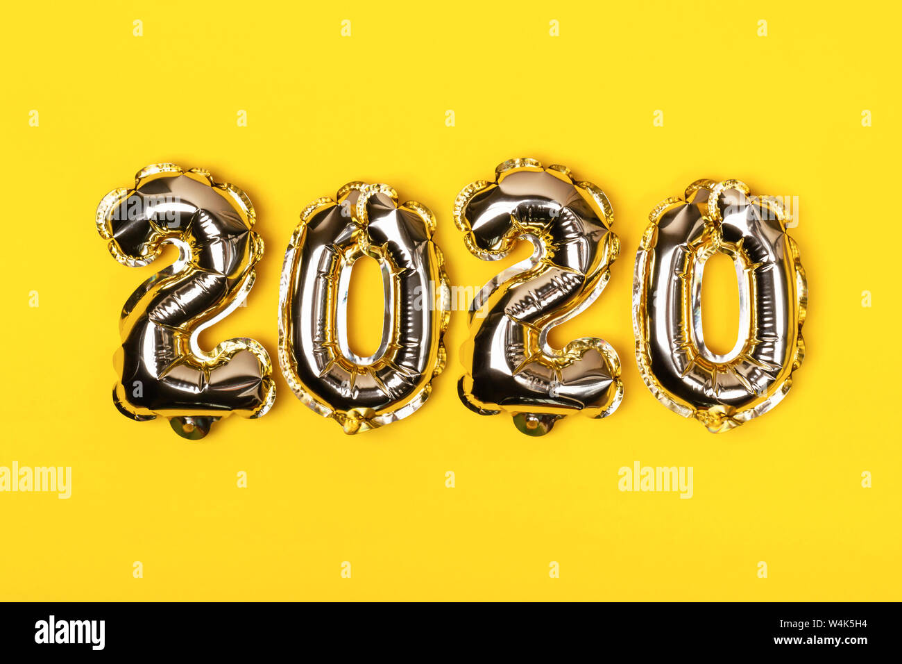 Golden foil balloons on yellow background. Inflatable numbers 2020 ...