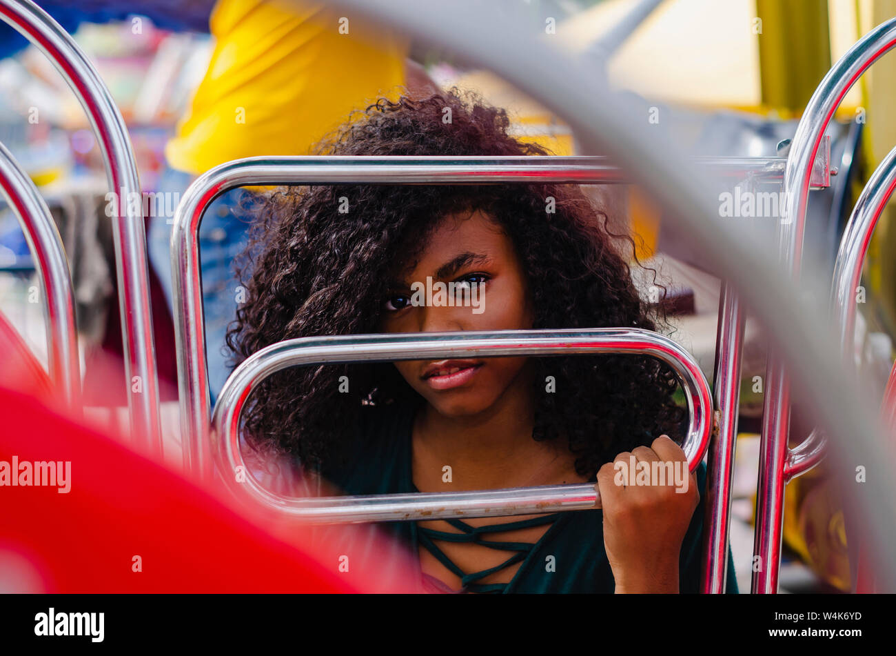 young girl of black color, laughing hair in ferris wheel, sitting ...