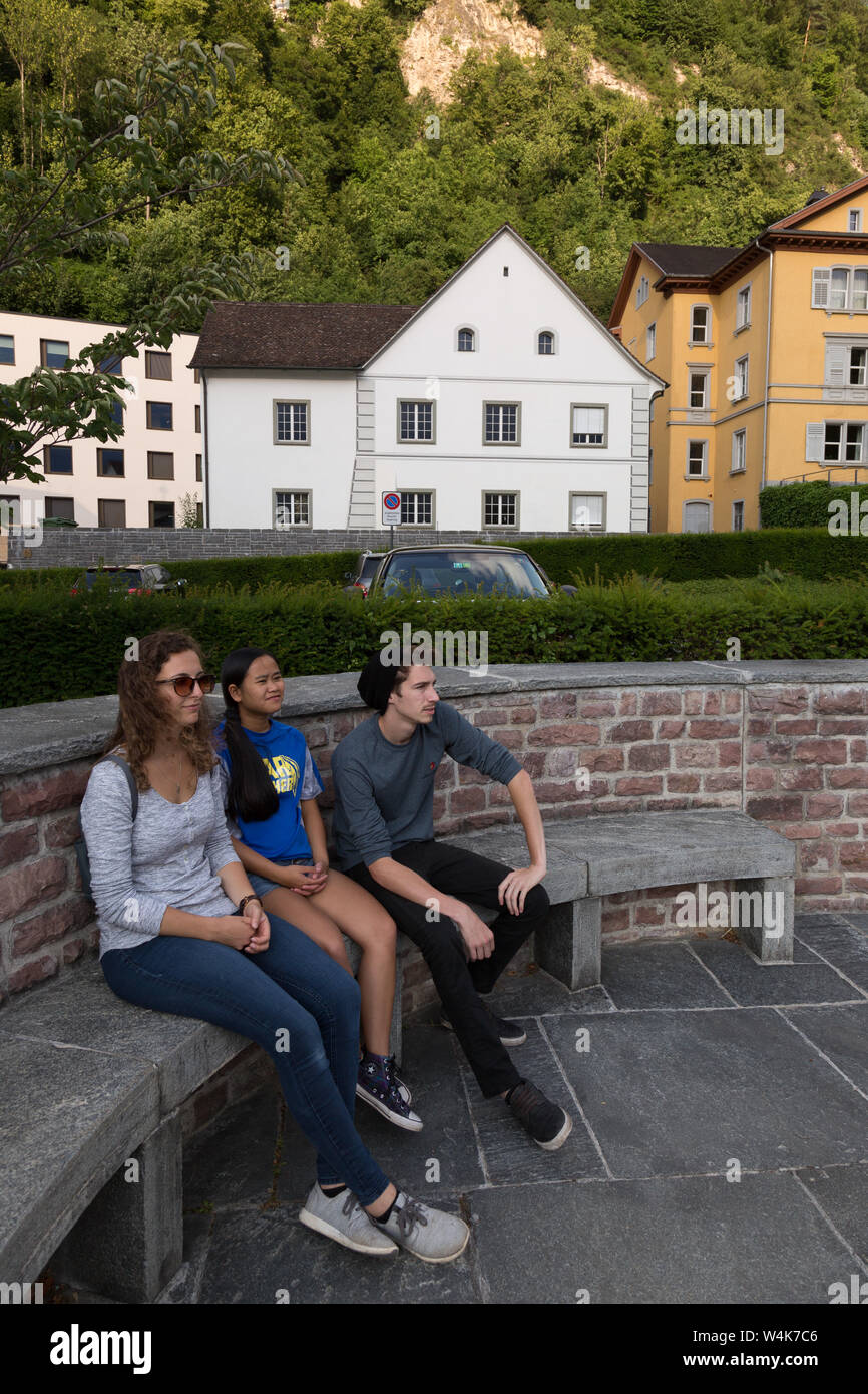 Three people sitting on a park bench hi-res stock photography and ...